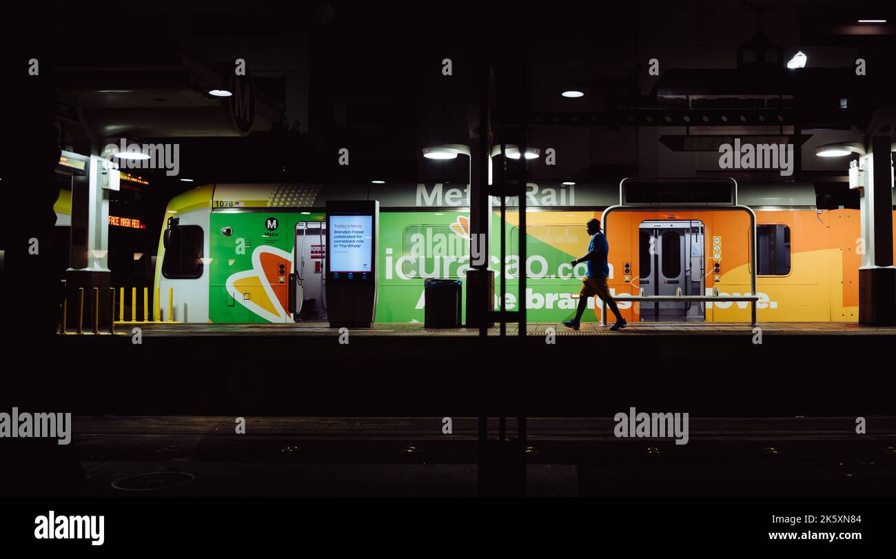 A man walks the train platform to catch a train to some other place ...