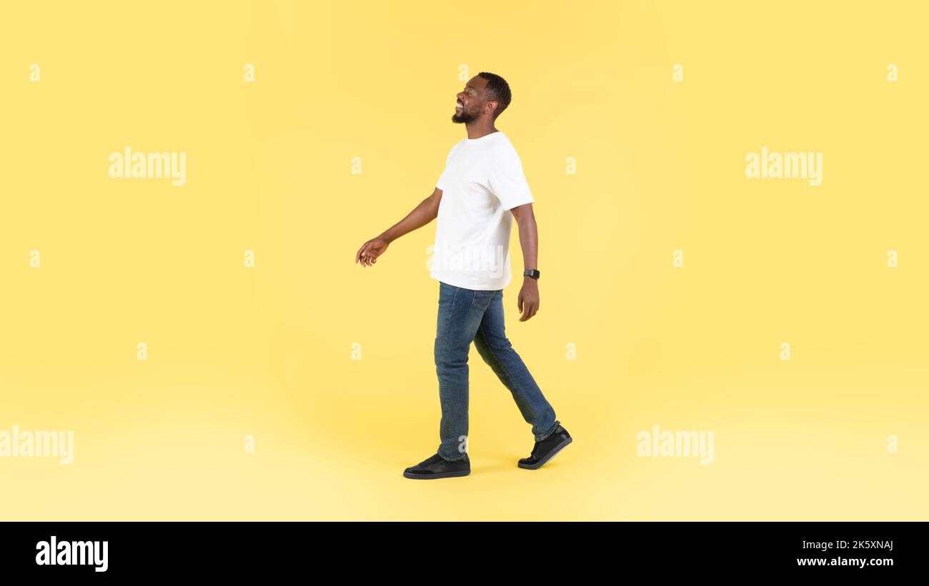Carefree African American Man Walking Smiling Looking Aside, Yellow ...