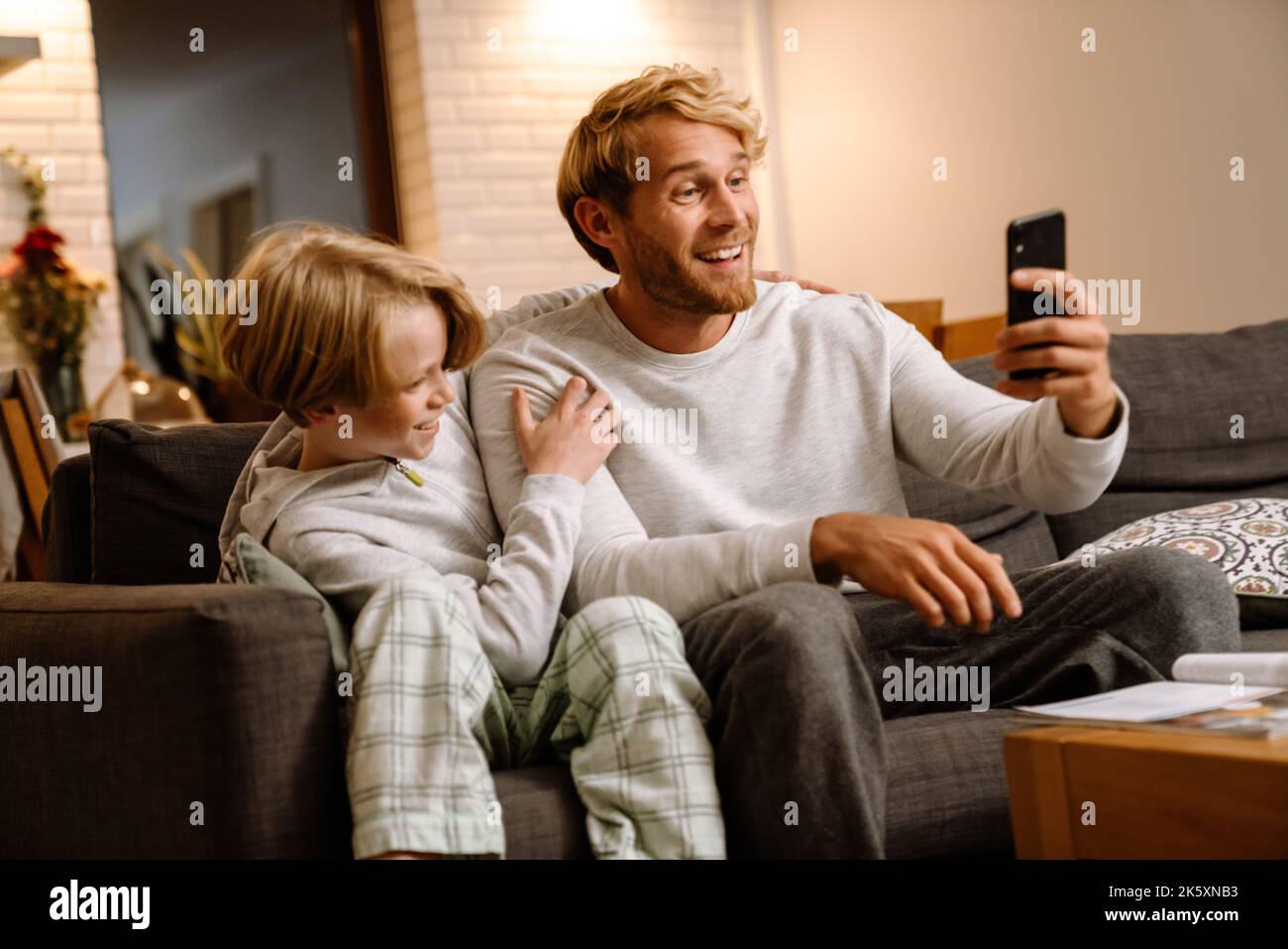 Ginger father and son taking selfie photo on cellphone while making fun ...