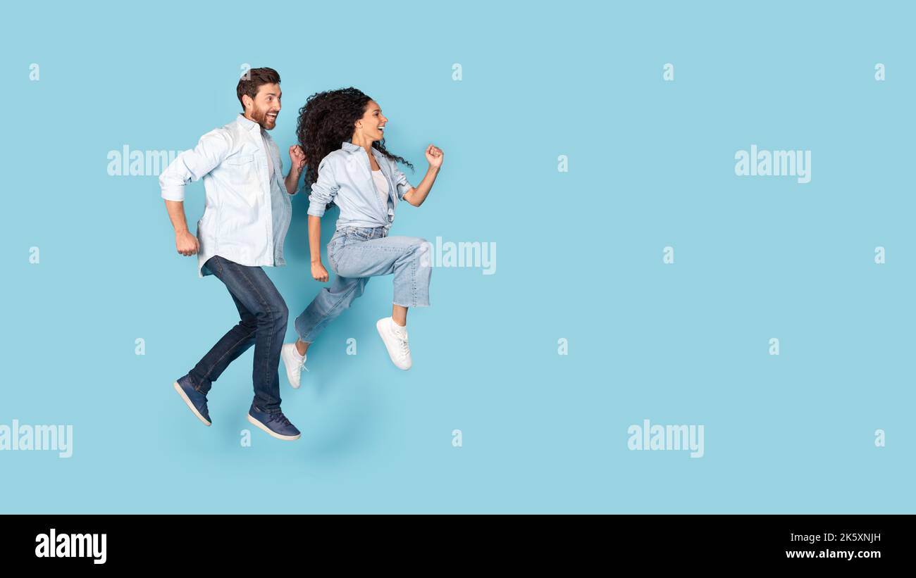 Happy millennial caucasian man and arab female fast run, jump in air to ...
