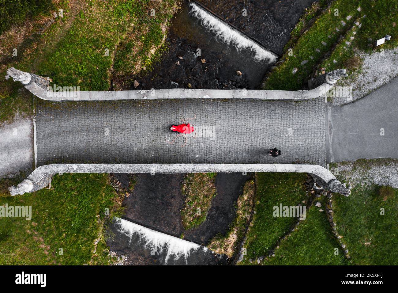 Stone arched bridge in the park, pedestrian bridge over the cascading ...