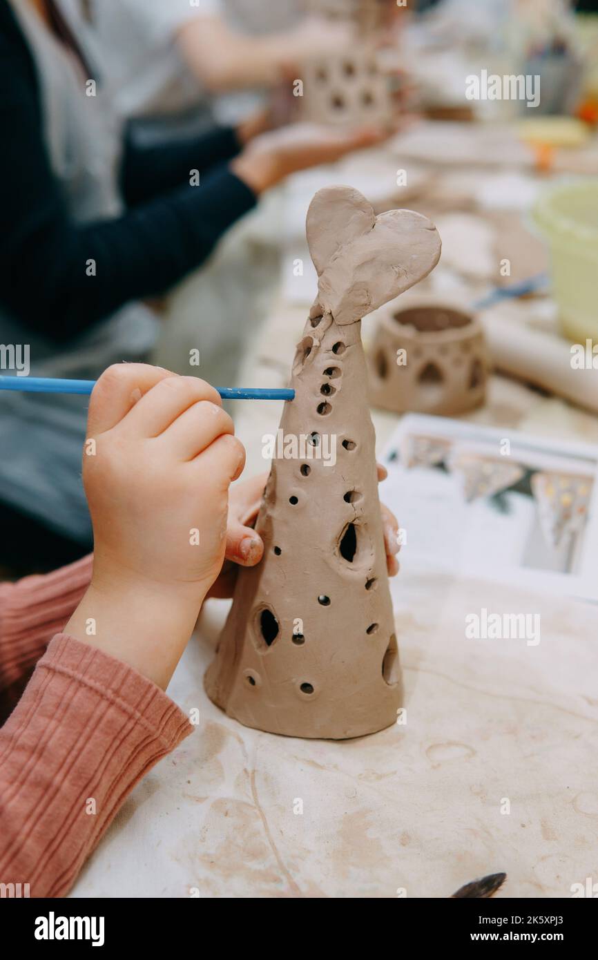 Baby hands knead clay, drawing elements of the product. Production of ...