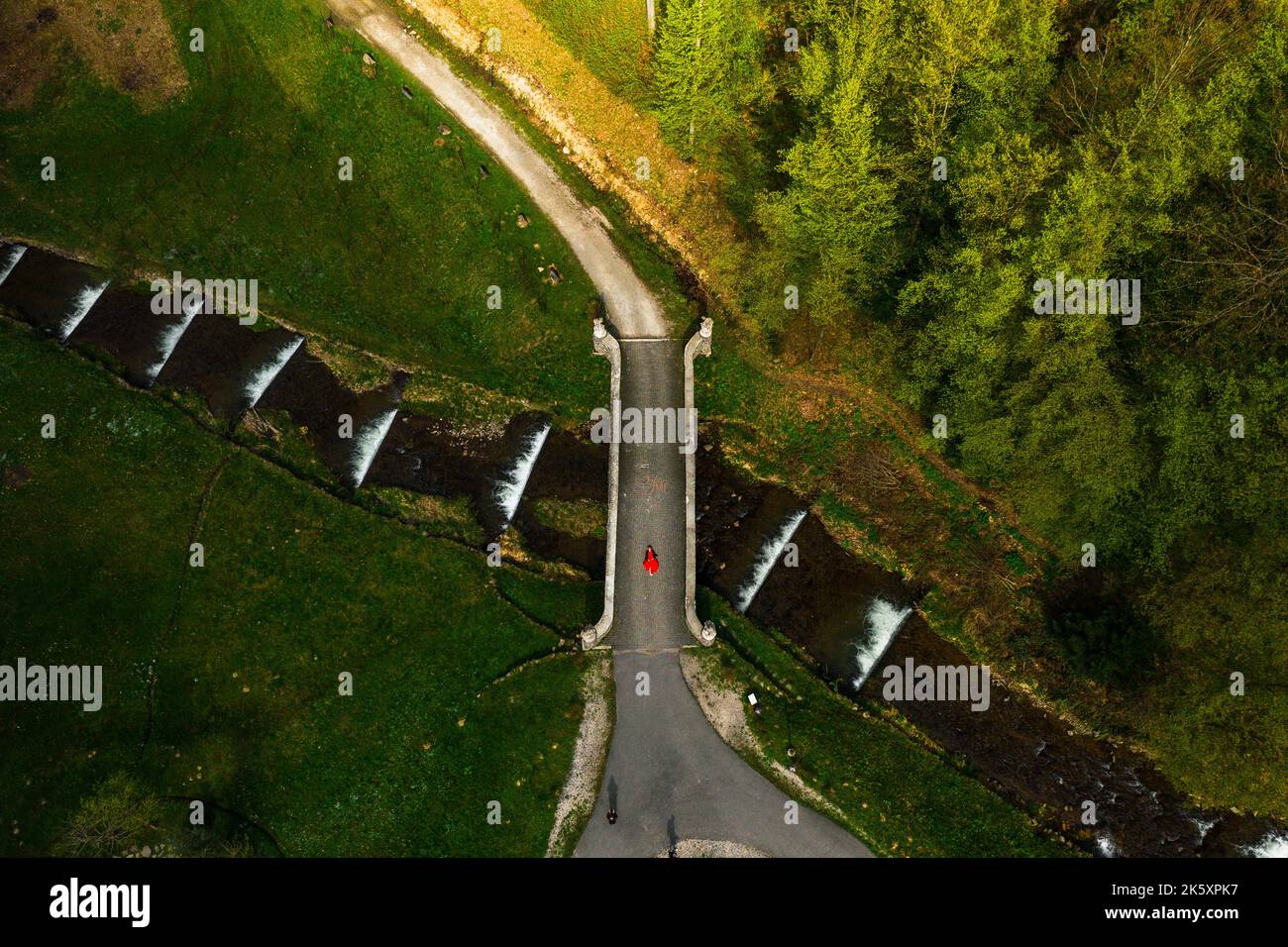 Stone arched bridge in the park, pedestrian bridge over the cascading ...