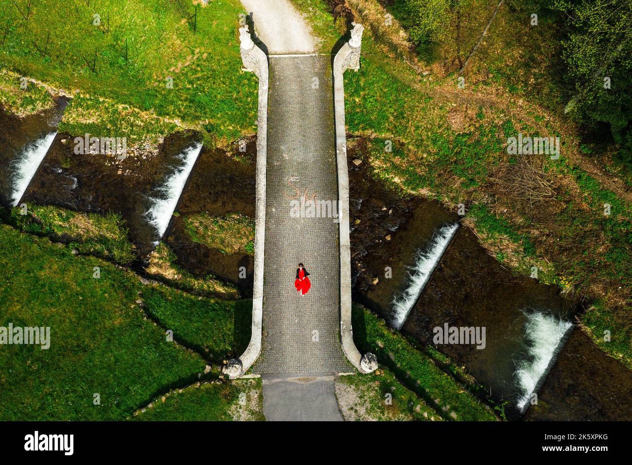 Stone arched bridge in the park, pedestrian bridge over the cascading ...