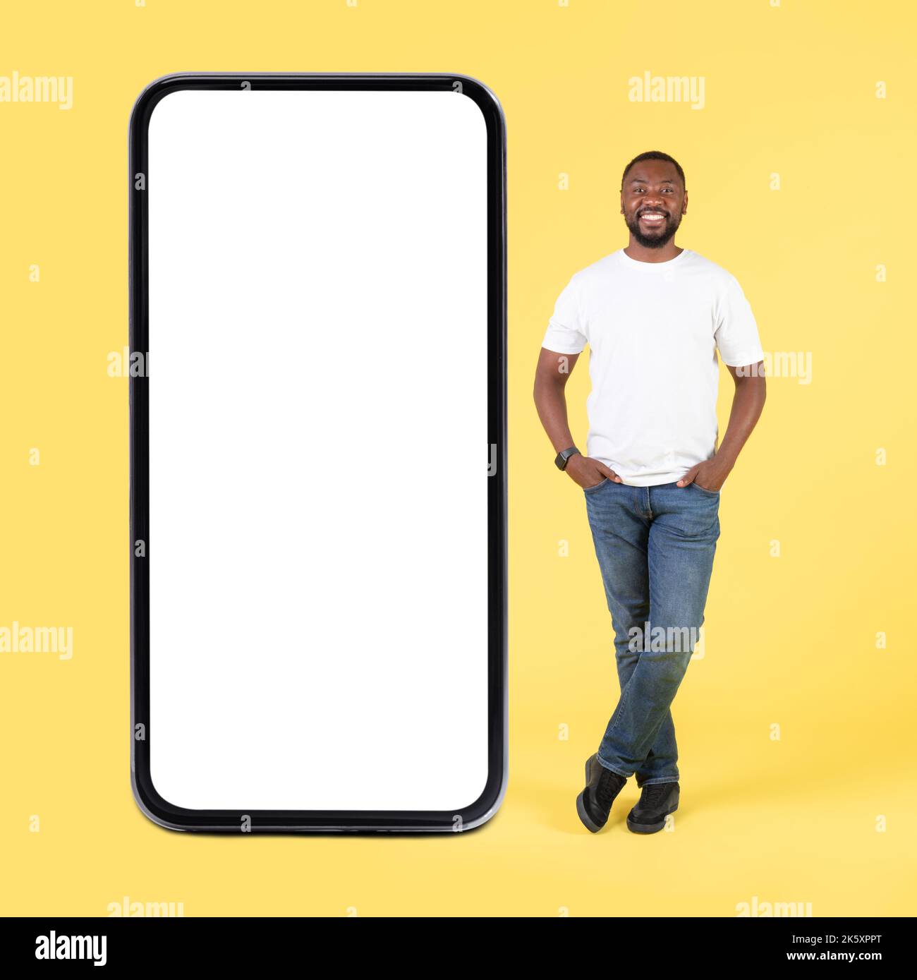 Cheerful African American Guy Standing Near Big Smartphone, Yellow ...