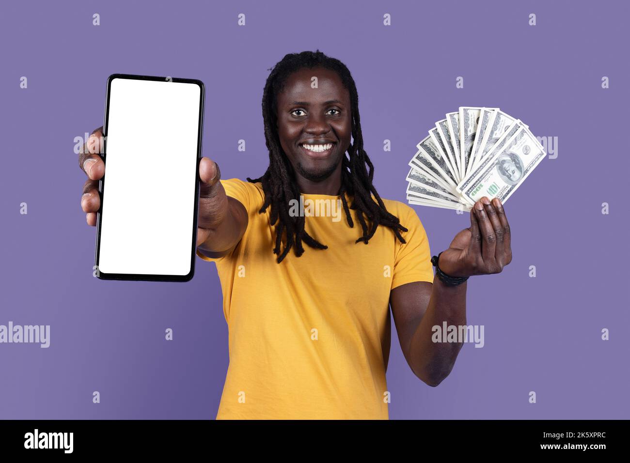 Happy wealthy black guy showing smartphone blank screen and cash Stock ...