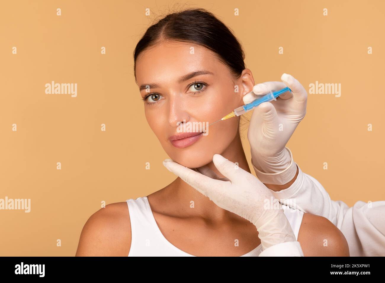 Lip augmentation concept. Doctor hands in gloves with syringe near ...