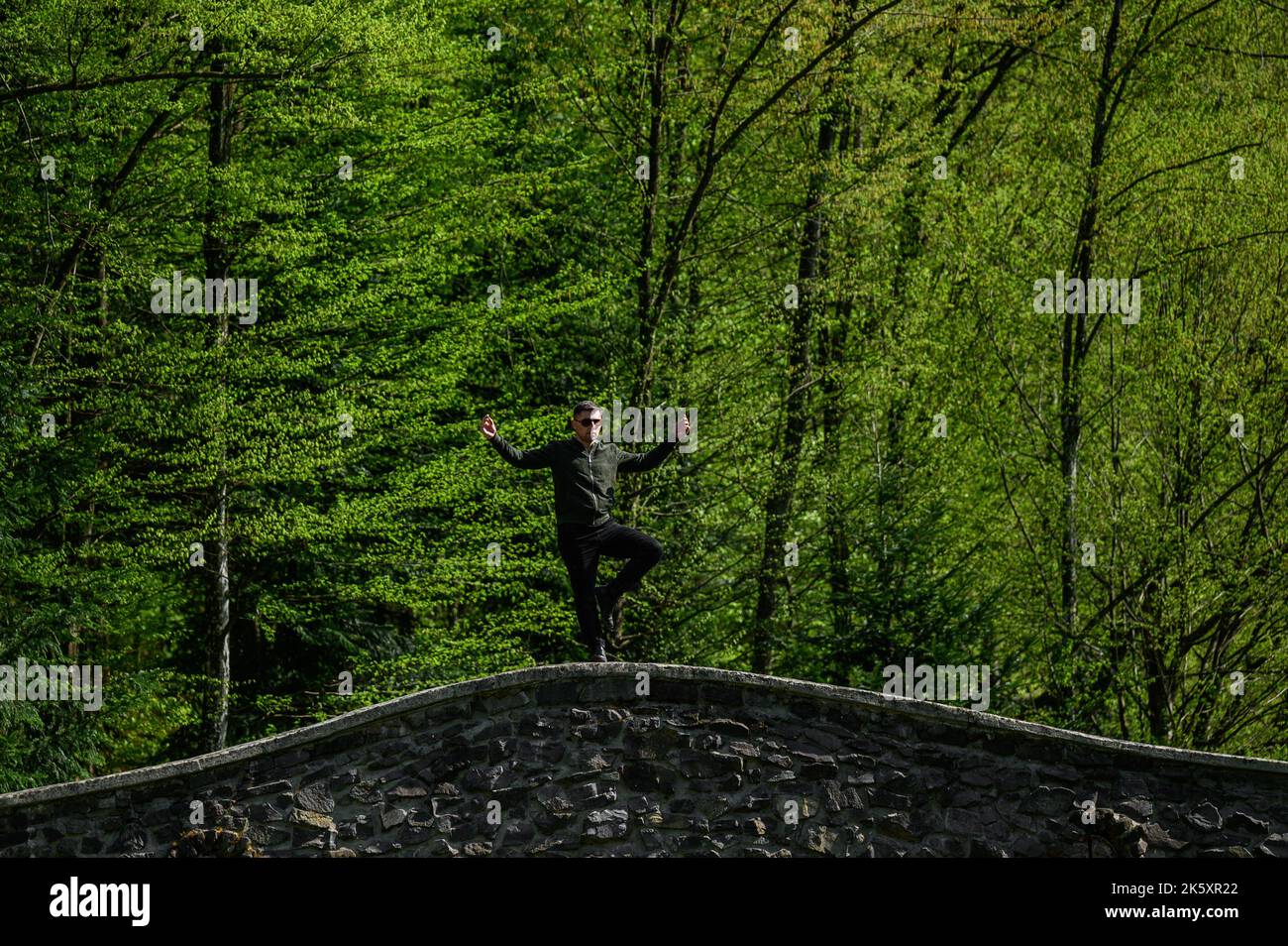 A man stands with one foot on the wall of the Gothic style, a photo ...