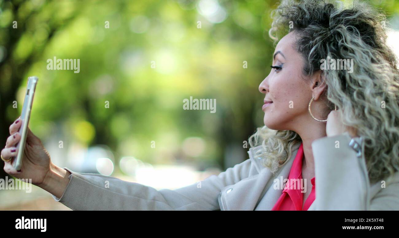 Woman taking selfie with phone camera outside of herself Stock Photo ...