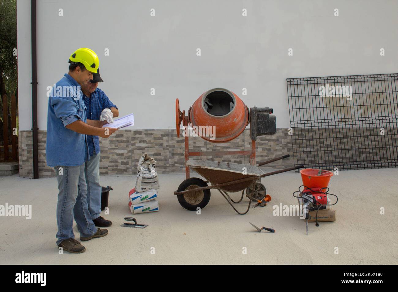 two men an engineer and a construction worker consulting the ...