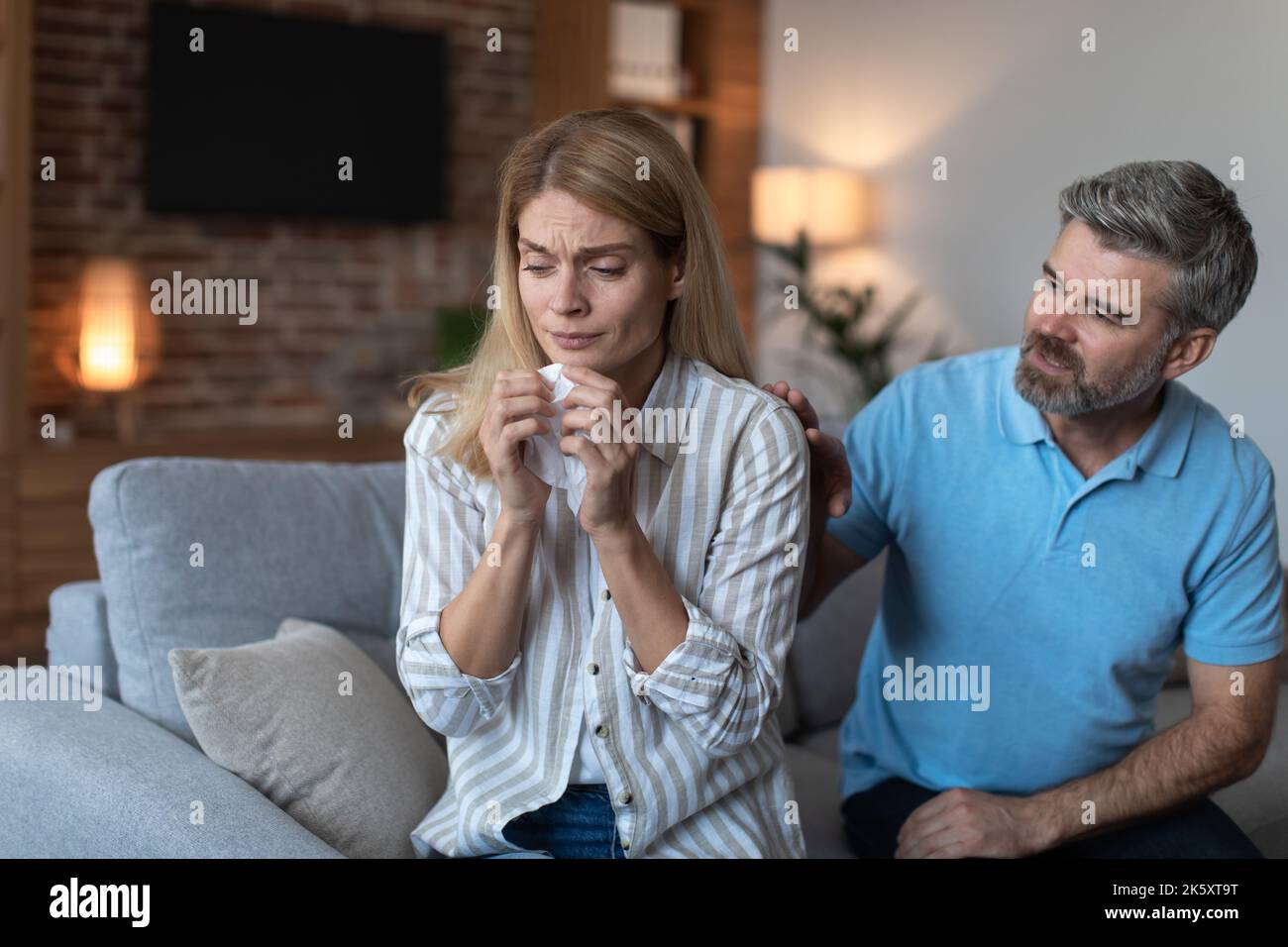 Sad middle aged european man calms crying female, got bad news in ...