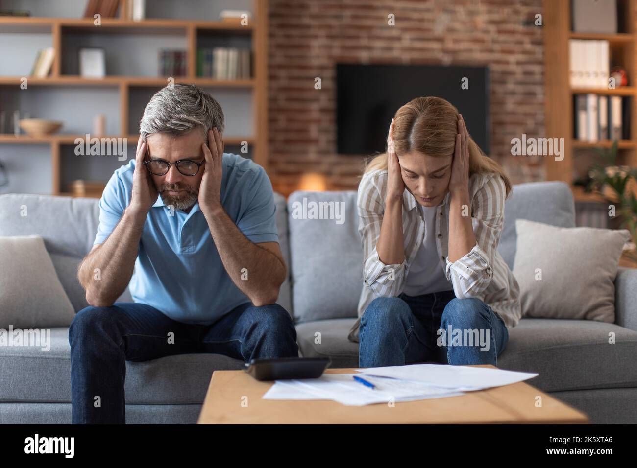 Despaired sad middle aged european couple suffer from bills in living ...
