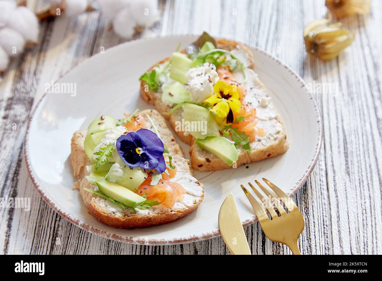 Aesthetic toasts with smoked salmon, avocado, cucumber and edible ...