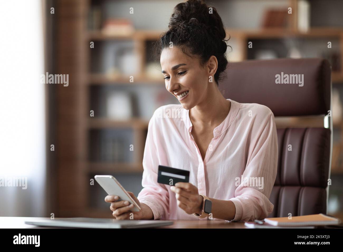 Happy young woman purchasing on Internet, using cell phone Stock Photo ...