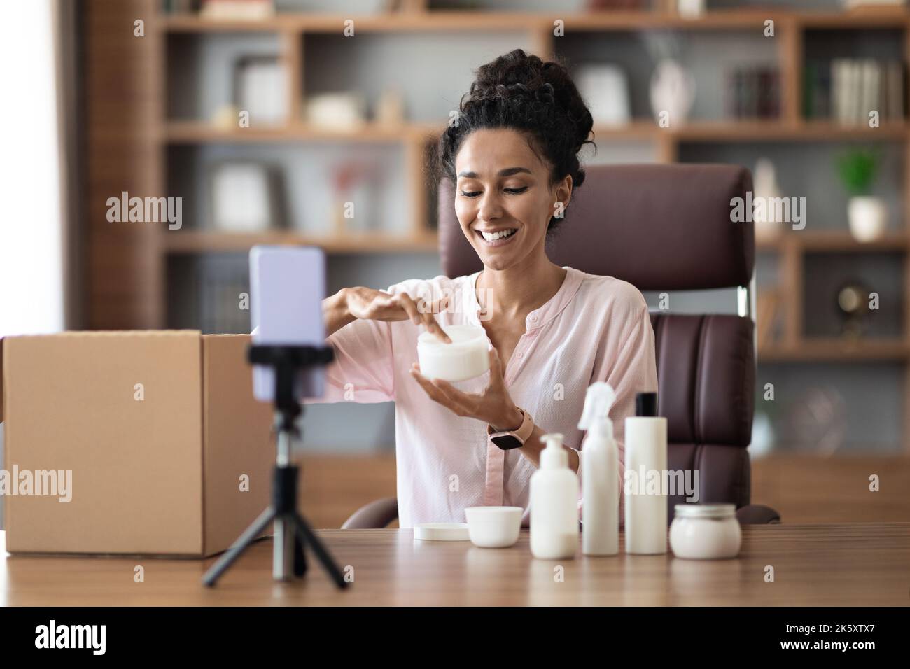 Pretty woman famous beauty blogger unpacking parcel at home, streaming ...