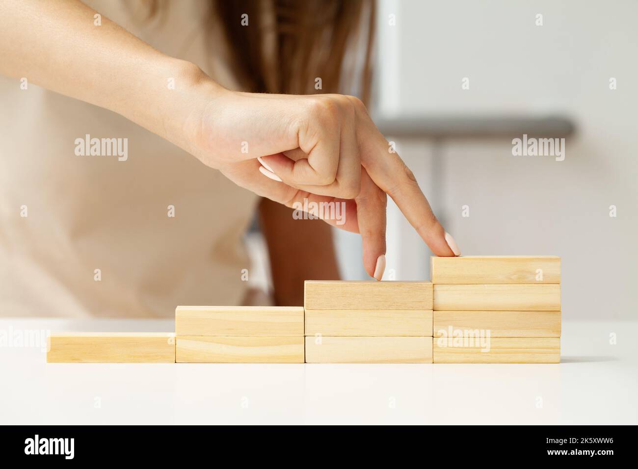 Hand arranging wood cube stacking as step stair Stock Photo - Alamy