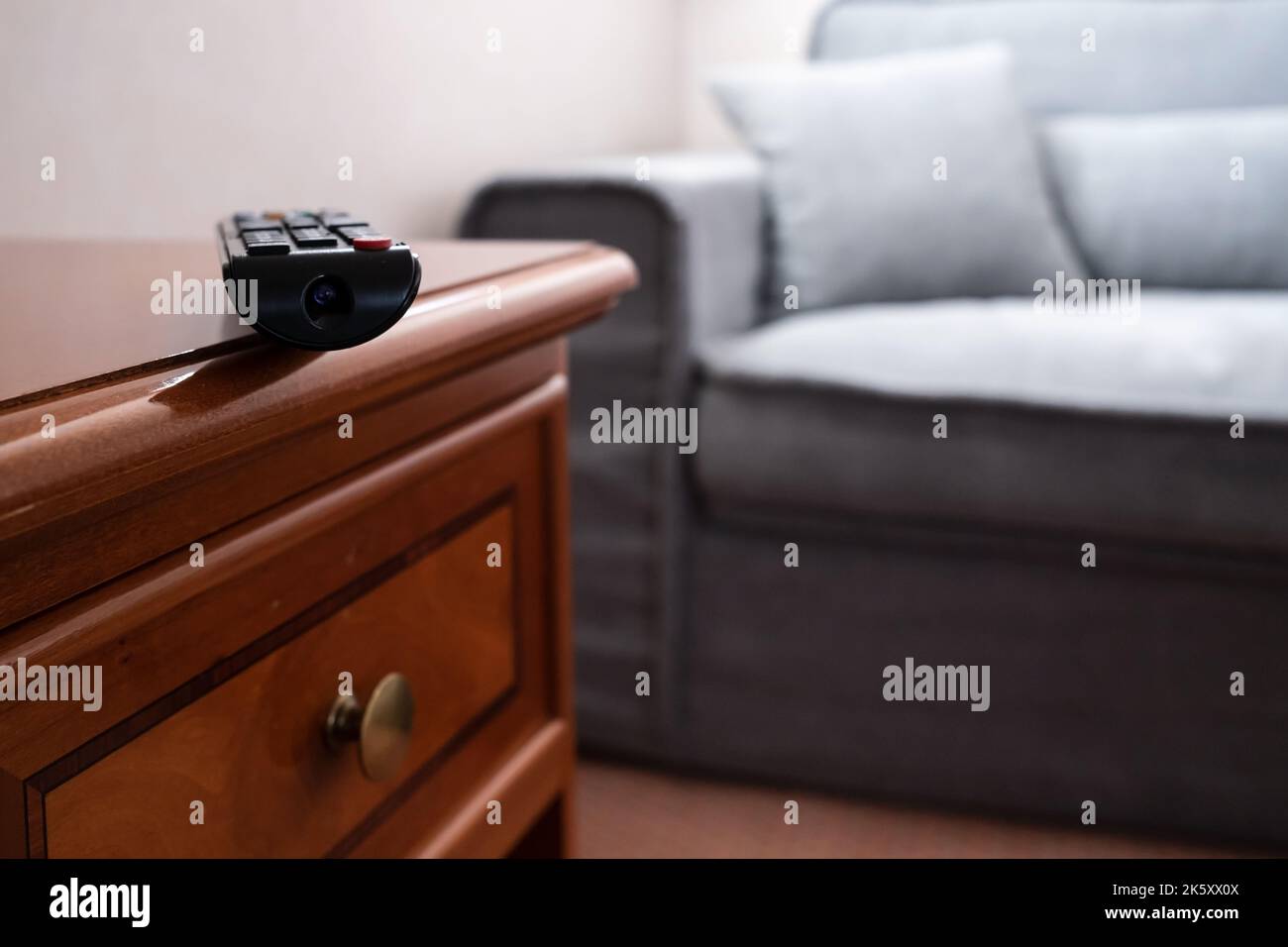 TV remote on the nightstand next to the sofa Stock Photo - Alamy