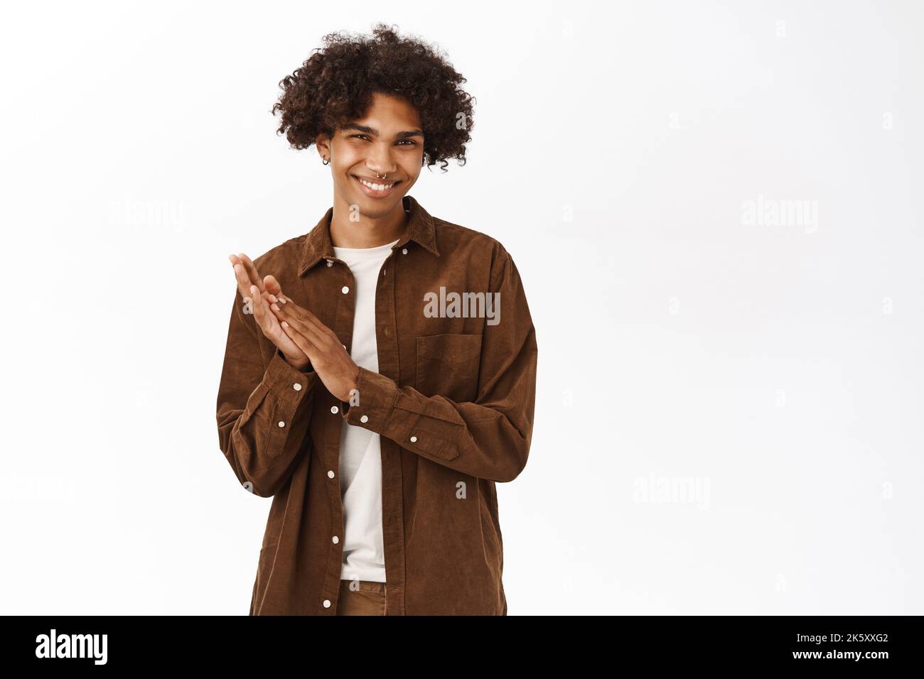 Pleased young guy smiles, applauses, praise and compliment you, clap ...