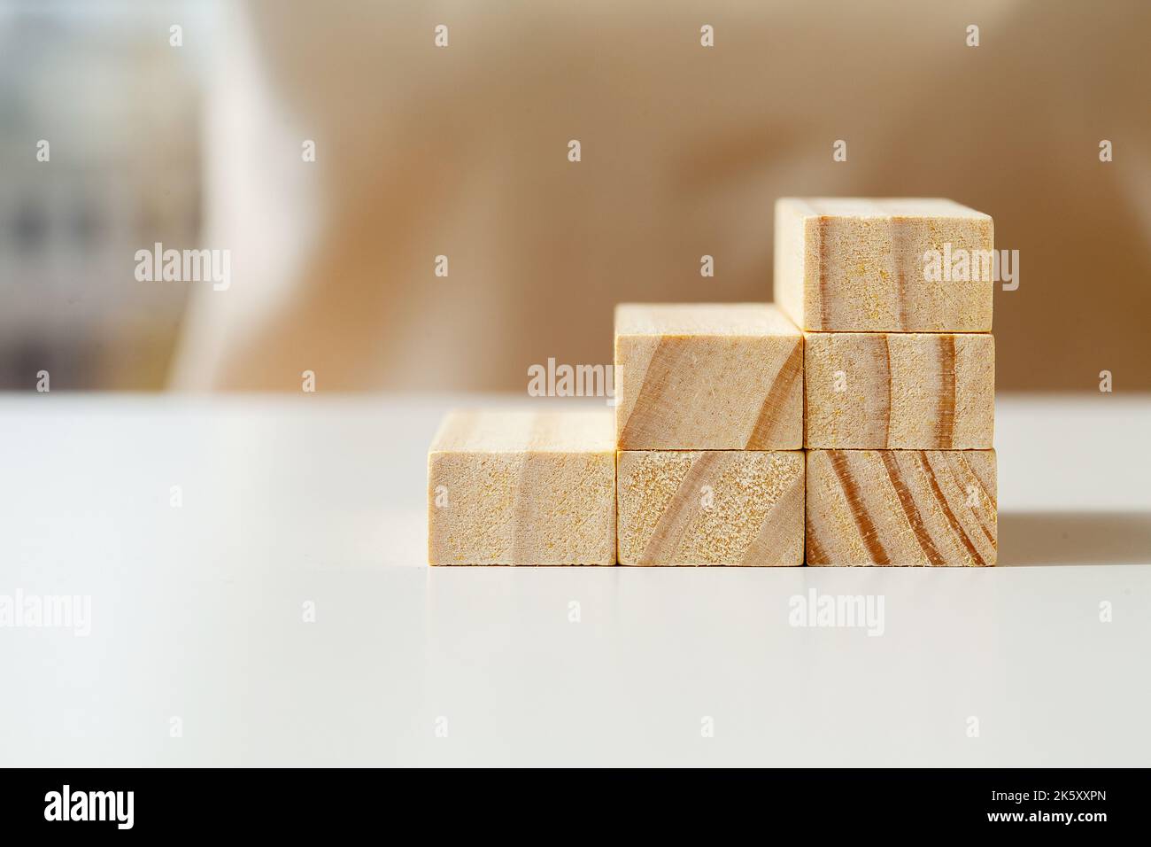 Hand arranging wood cube stacking as step stair Stock Photo - Alamy