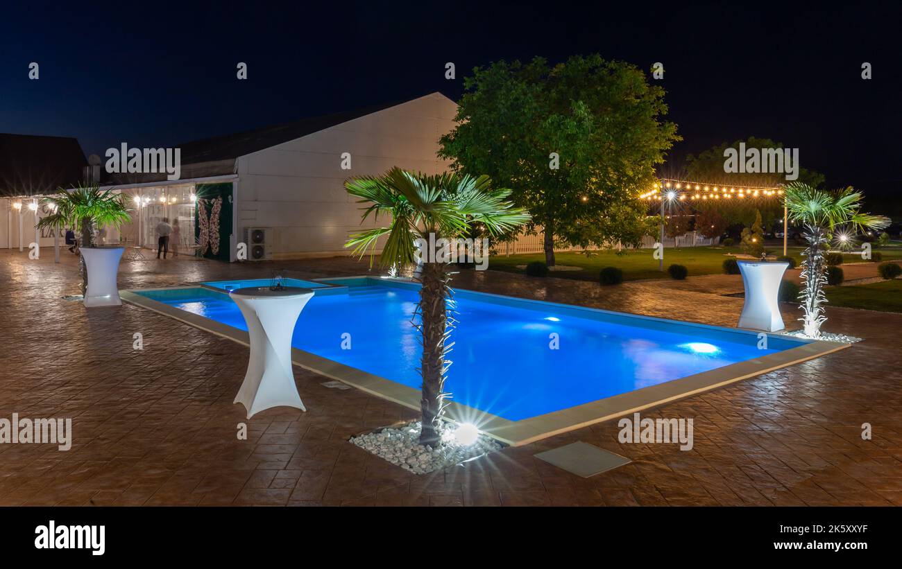 A swimming pool in a ballroom with decorations at night Stock Photo - Alamy