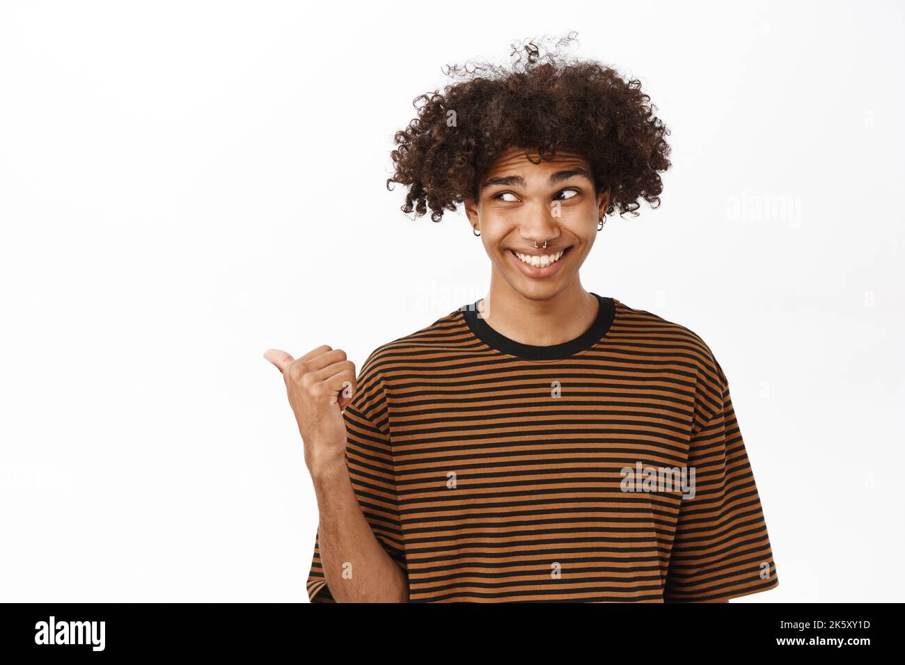 Close up of handsome smiling guy, pointing finger left and giggle over ...