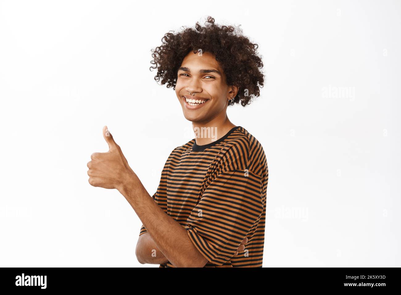 Very nice. Portrait of happy, satisfied young man, shows thumbs up and ...