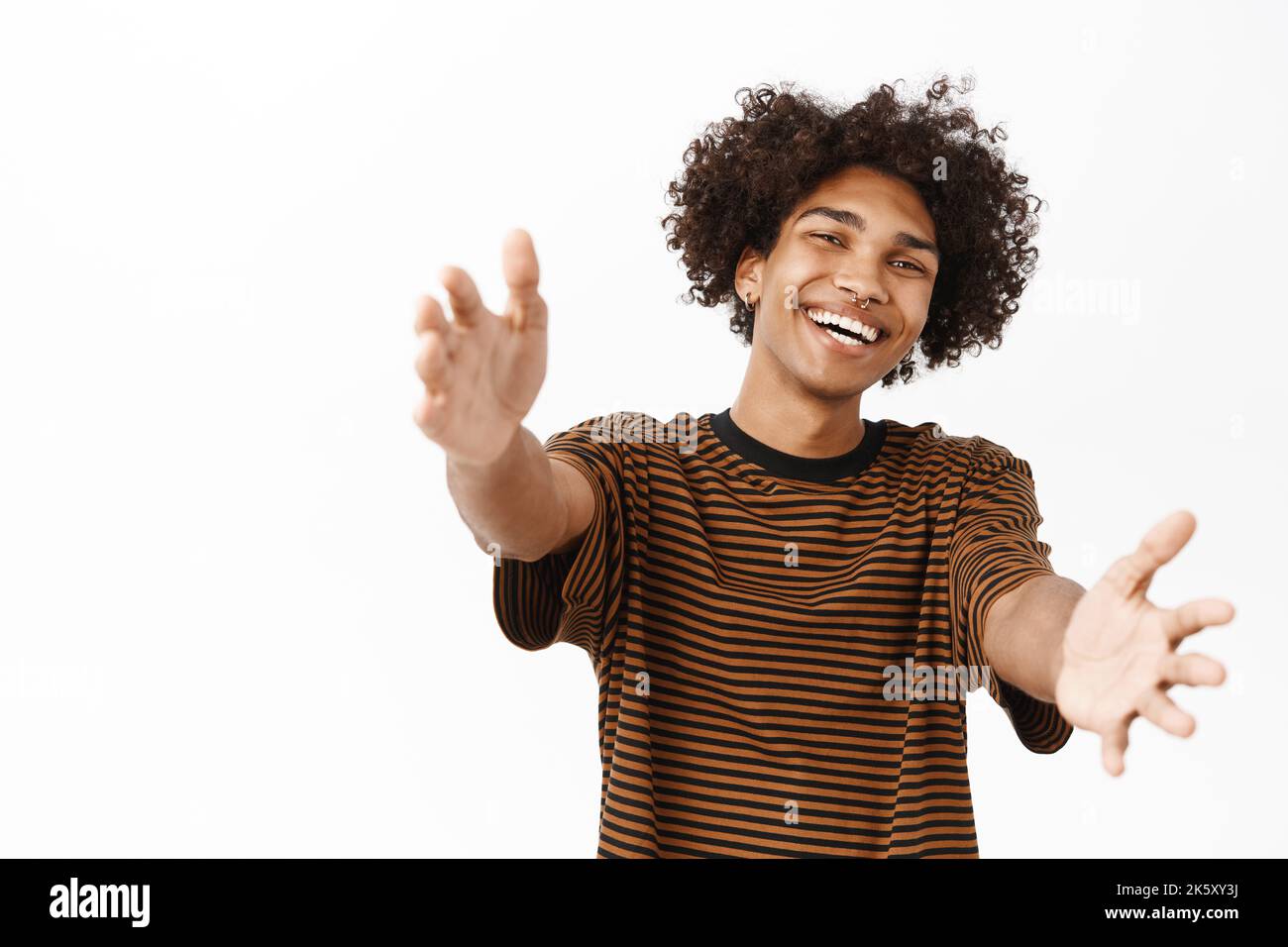 Happy smiling guy stretching out arms towards you, hugging, receiving ...