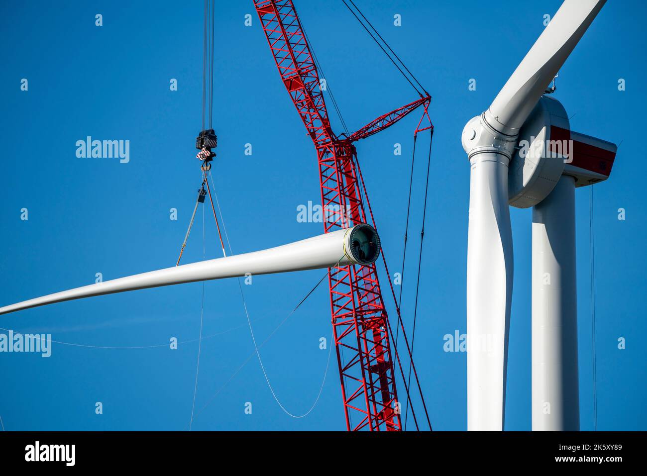 Assembly of a wind turbine, the last rotor blade is being mounted ...