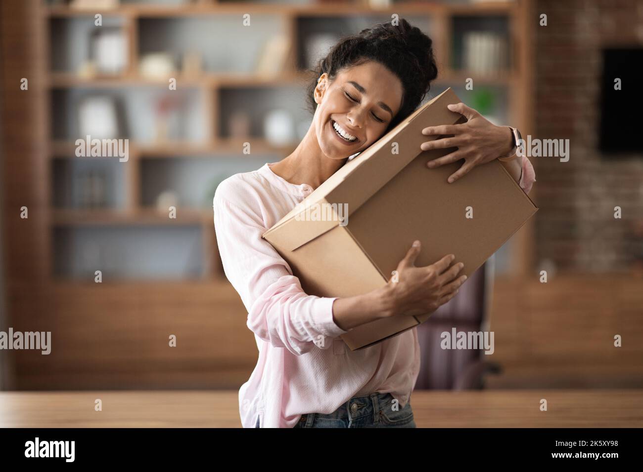 Delighted woman customer hugging paper box parcel Stock Photo - Alamy