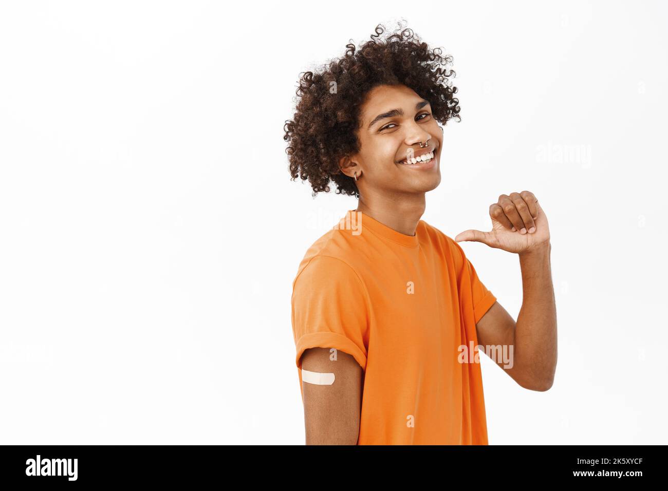Handsome smiling young man, did covid-19 vaccination shot on arm ...