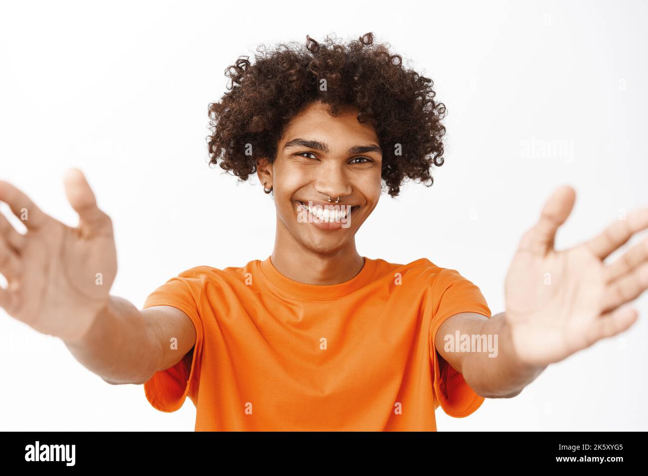 Close up portrait of smiling hispanic man reaching out his hands ...
