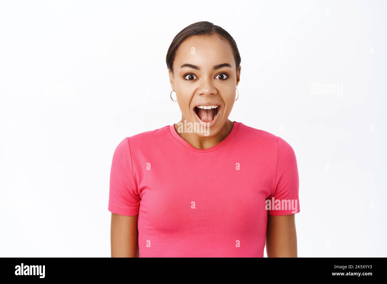 Close up of enthusiastic young woman, looking surprised and amazed ...
