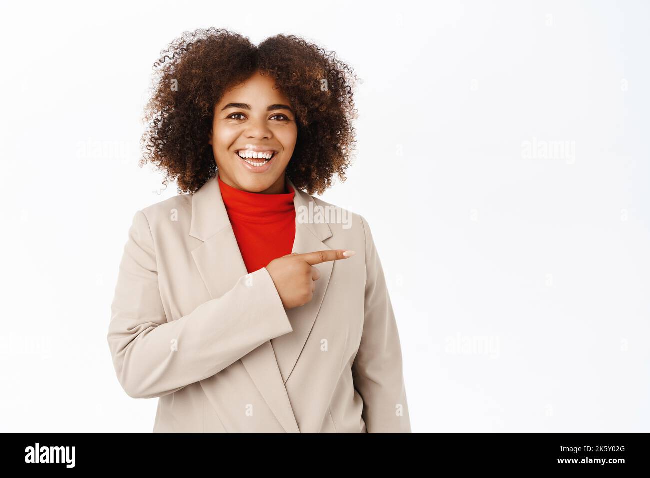 Young smiling saleswoman, business lady pointing finger right, shows ...