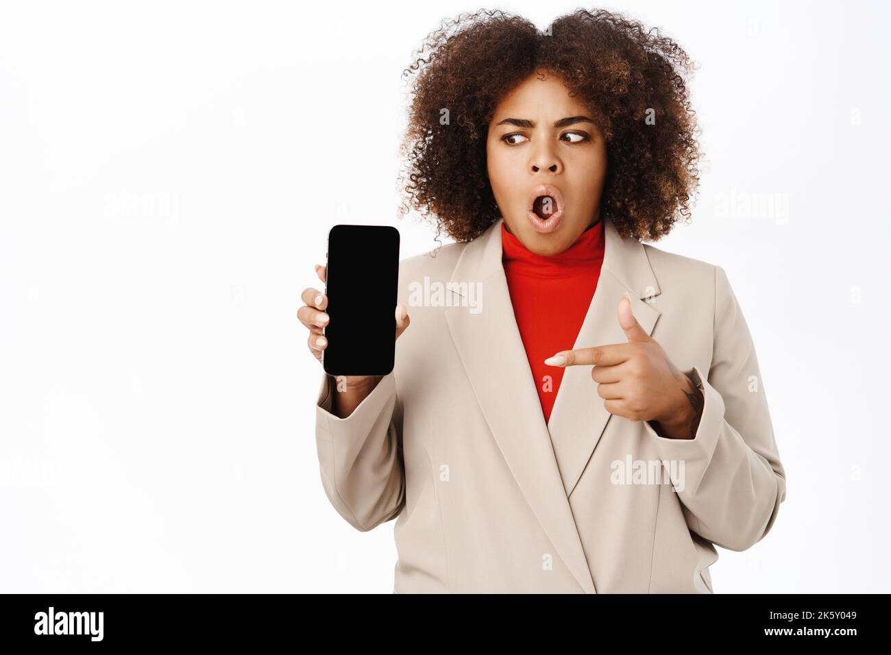 Technology. Shocked african american businesswoman, points and looking ...