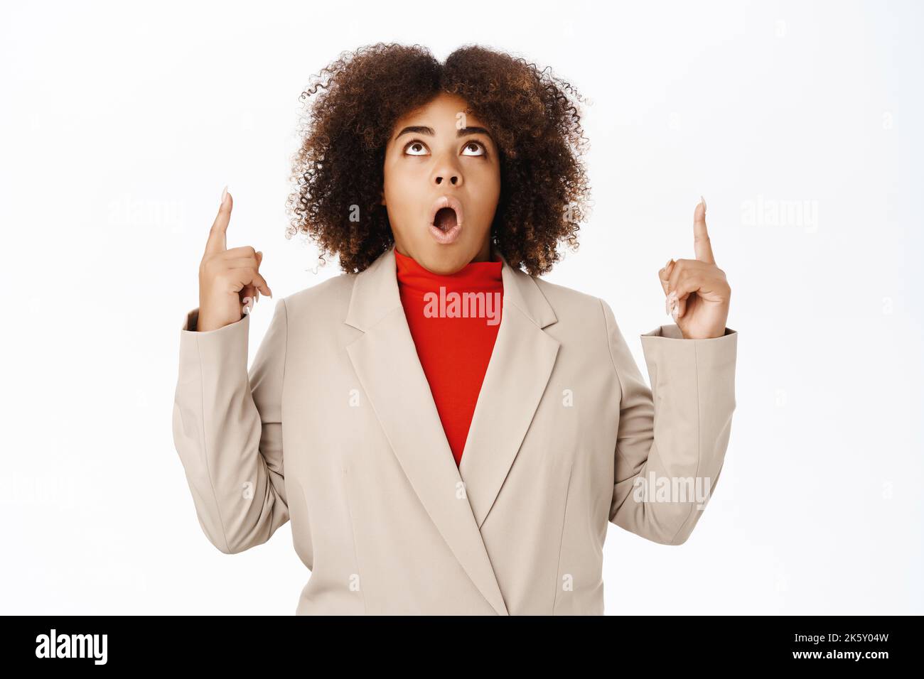 Portrait of surprised black woman, saleswoman pointing fingers up ...