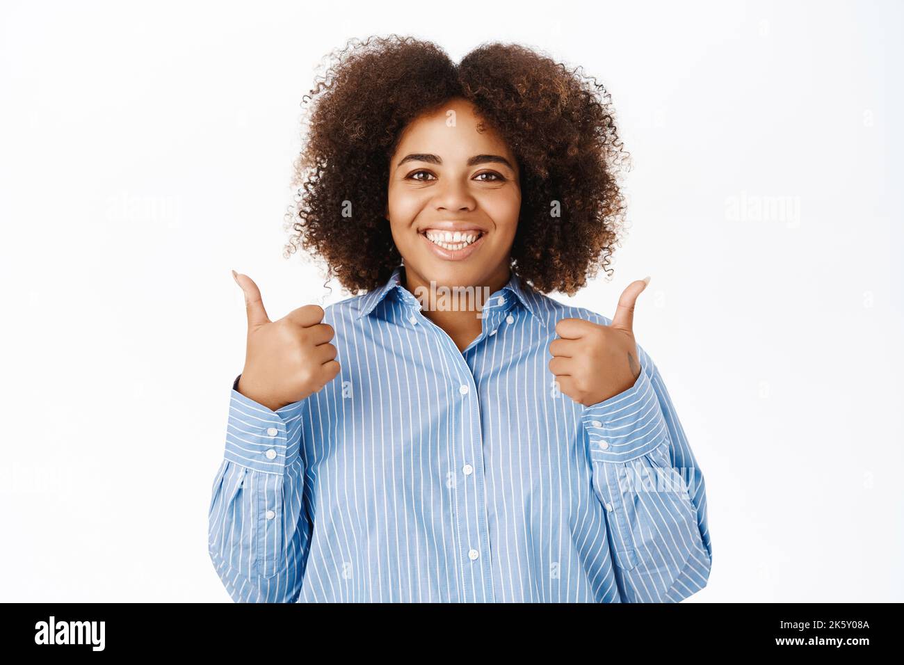 Smiling black woman shows thumbs up, recommends smth, approve and ...