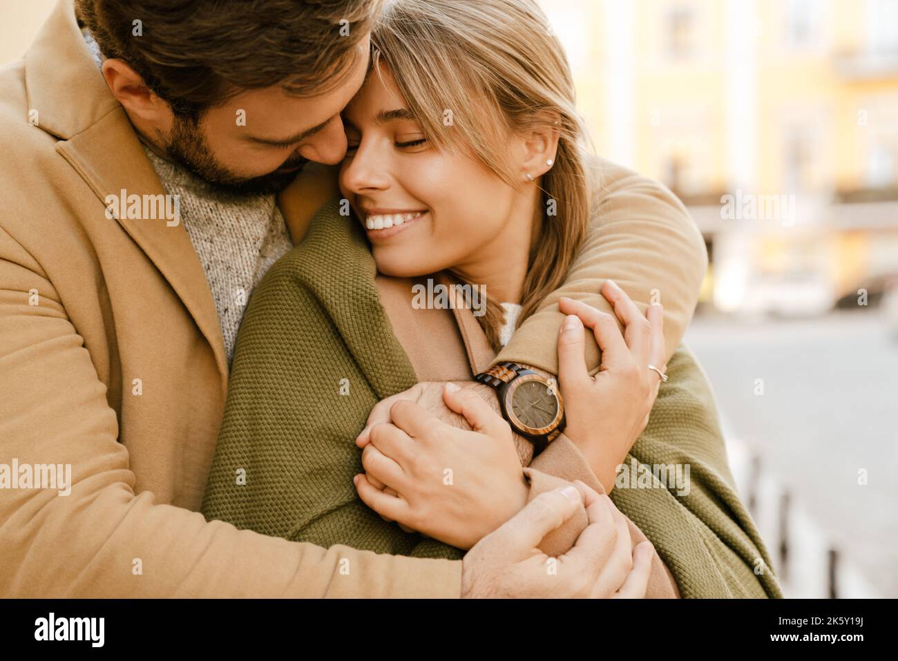 White romantic couple smiling and hugging while standing outdoors Stock ...