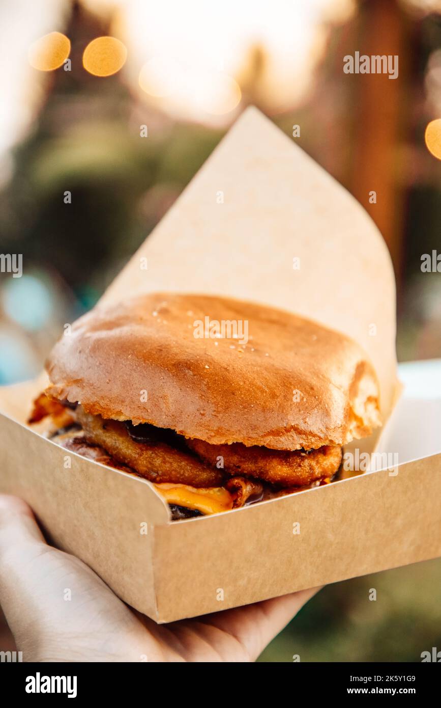 Burger in paper and paper cardboard. Fast food at the festival Stock ...