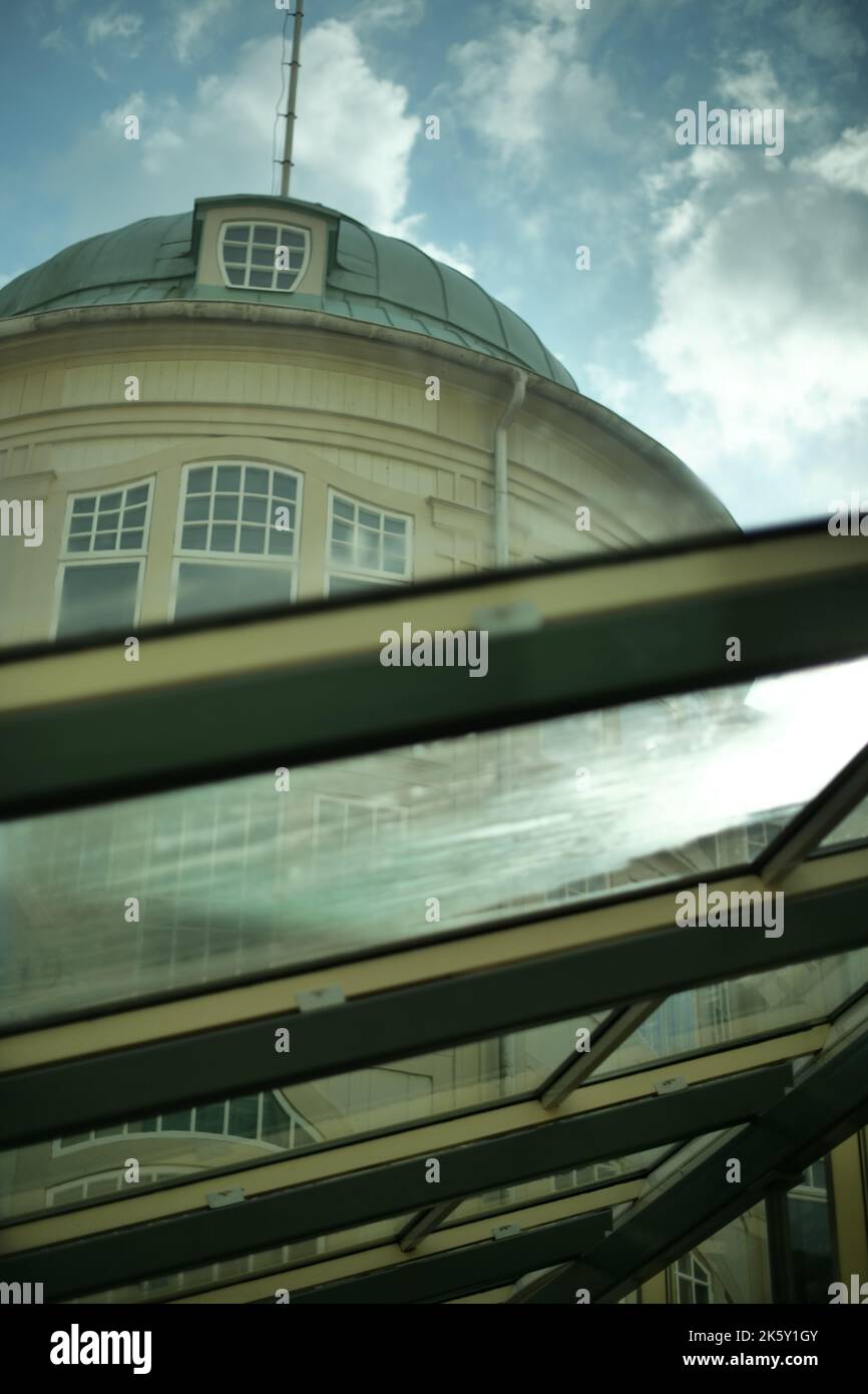 A vertical shot of the top of round building seen behind transparent ...