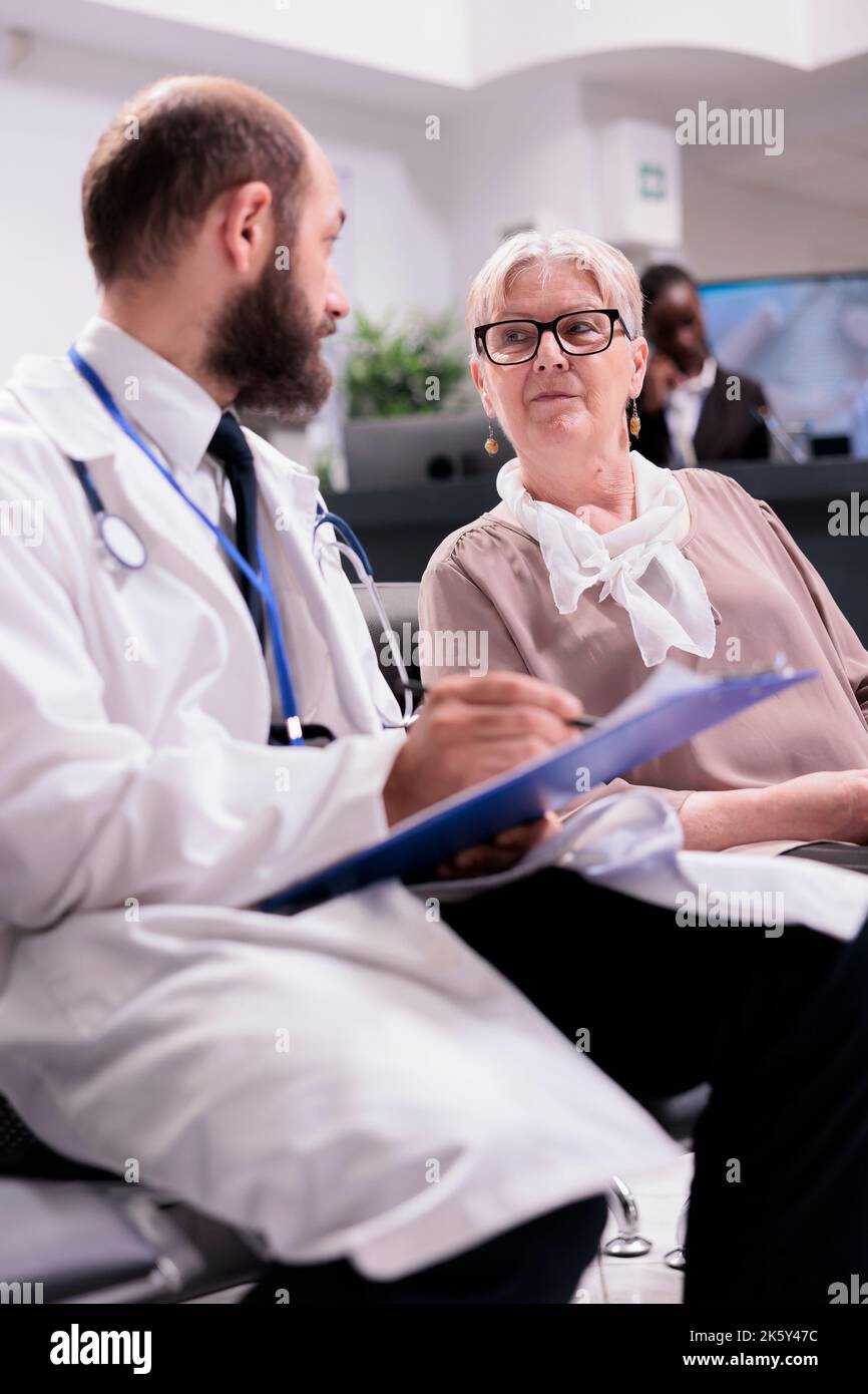 General practitioner filling out disability application for elderly ...