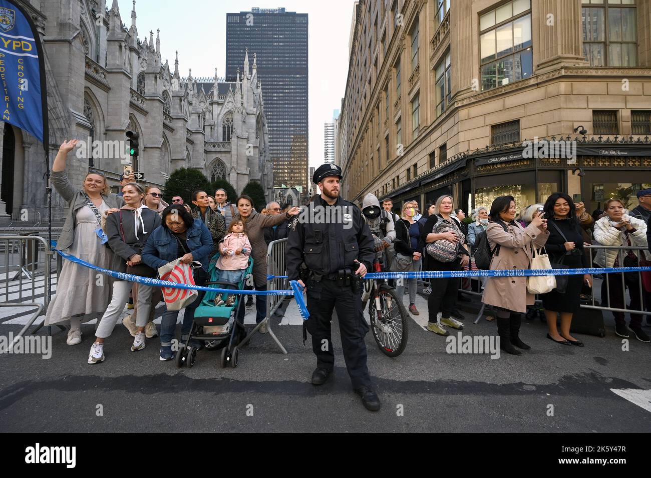 New York, NY, October 10, 2022, An NYPD officer hols blue police tape ...