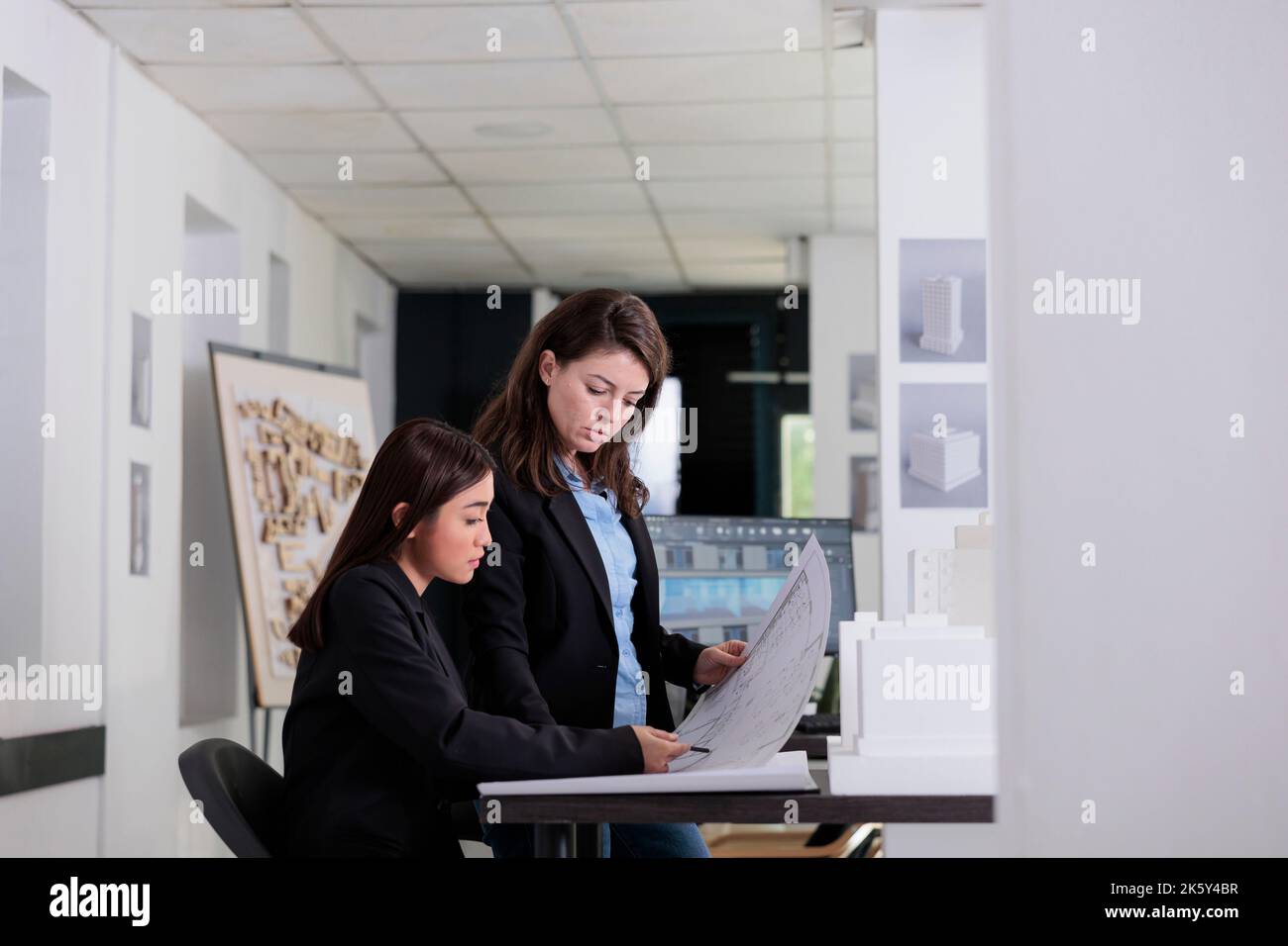 Architects holding blueprint, discussing construction project sketch ...
