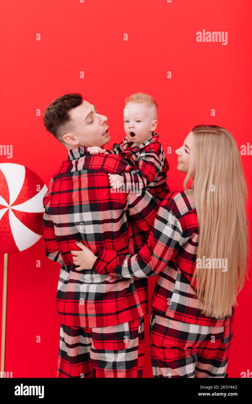 smiling young mother and father are kissing and hugging their baby boy ...