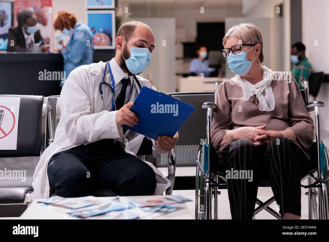 Physician talking to senior patient who lives with chronic disability ...