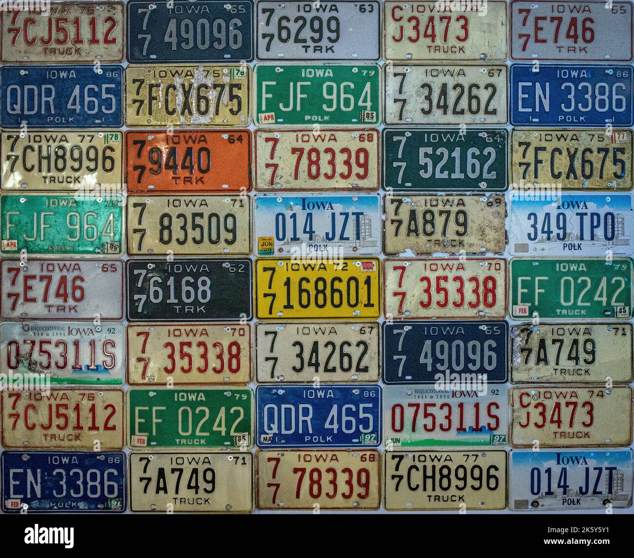 A closeup shot of a wall decorated with colorful Iowa license plates ...