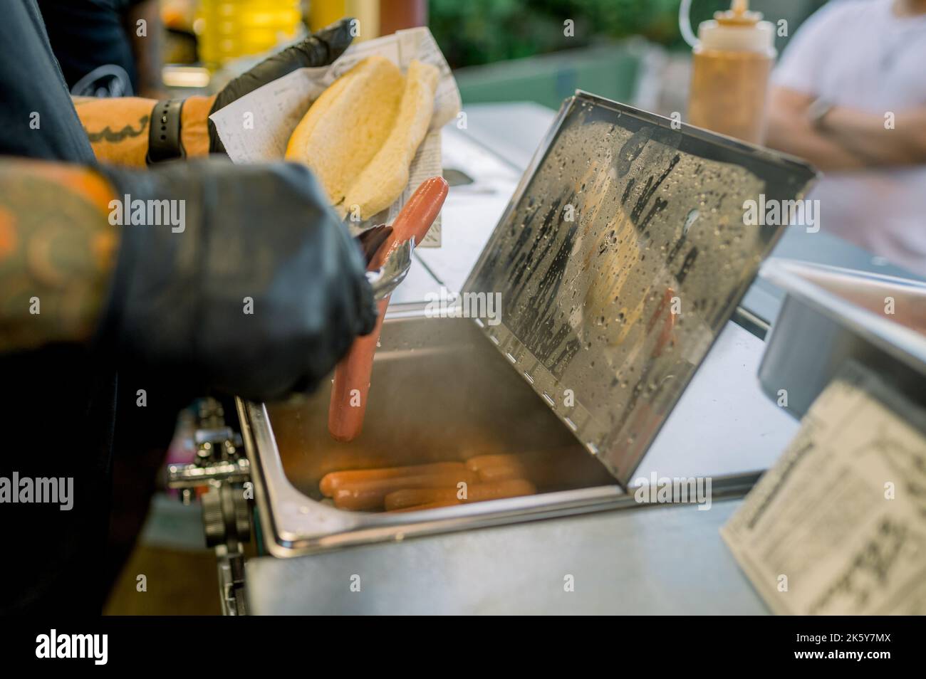 Crop vendor cooking hot dog on street Stock Photo - Alamy