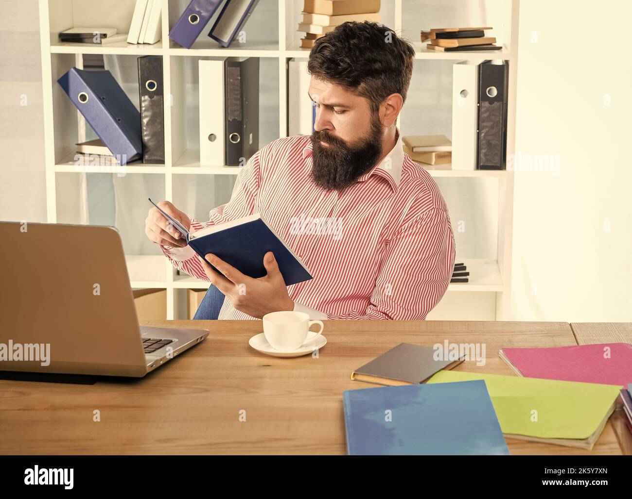 Serious lawyer reading book at office desk Stock Photo - Alamy