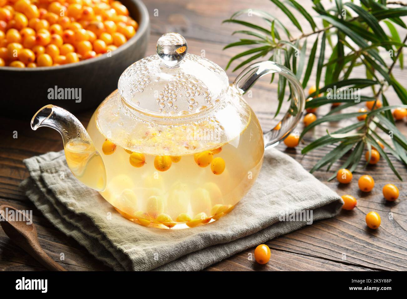 Glass tea kettle of healthy sea buckthorn tea, ripe sea buckthorn ...