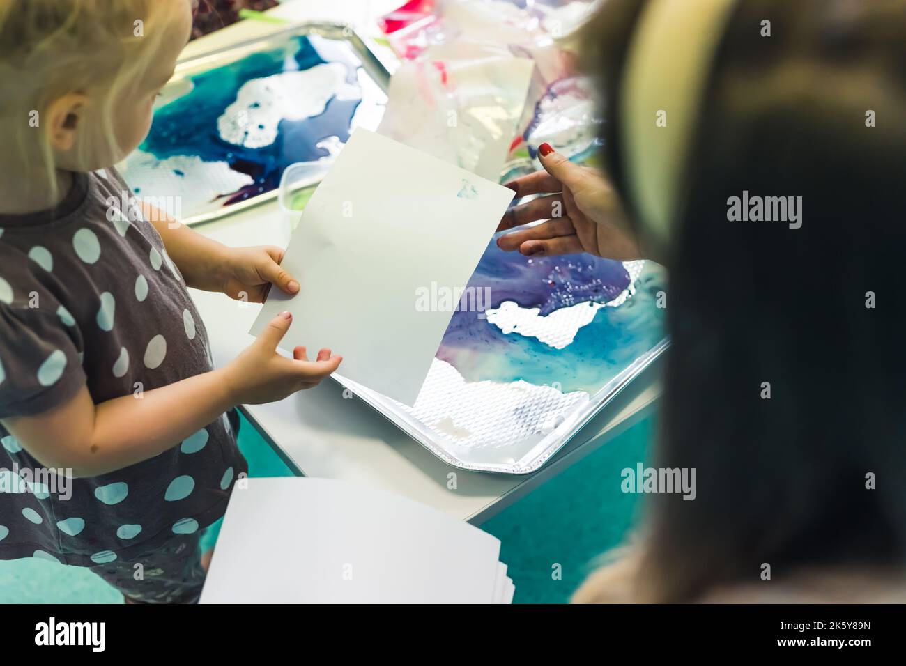 let me show you how to paint - a teacher helping preschoolers to paint ...
