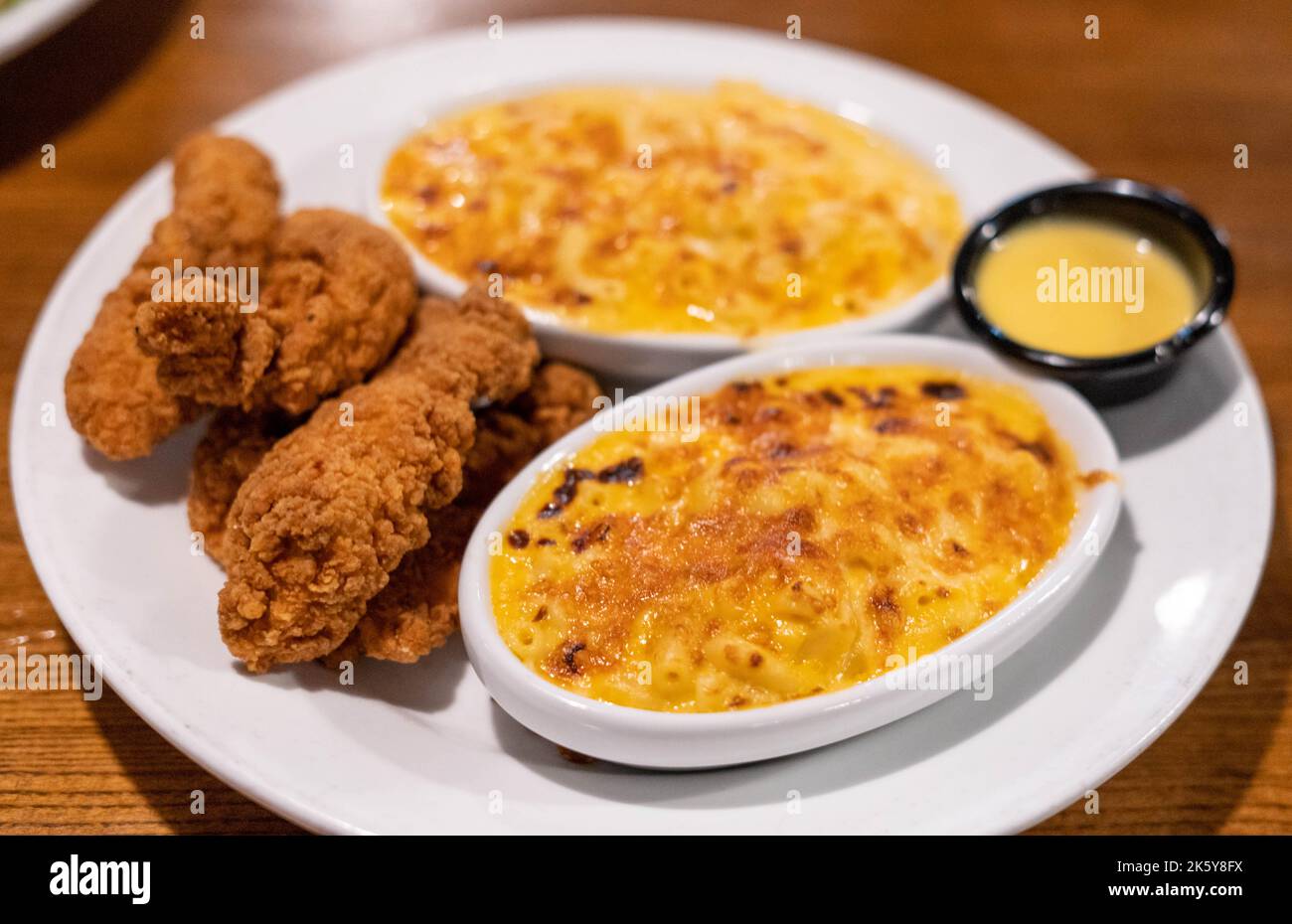 Plate of chicken fingers with accompaniment of macaroni and cheese ...